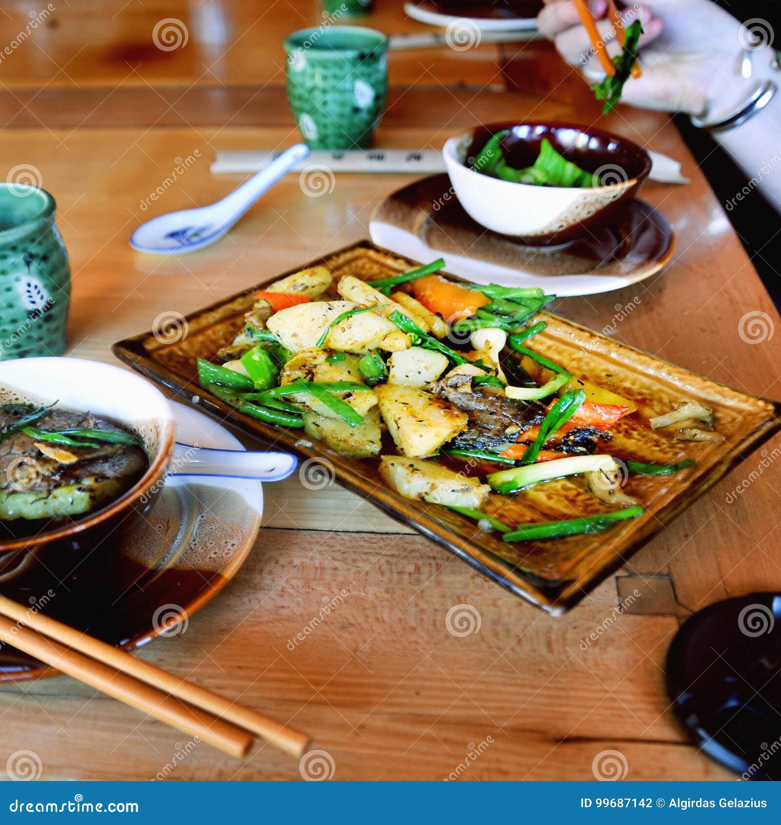 Hand with Chopsticks and Dinner Table Stock Photo - Image of setting ...