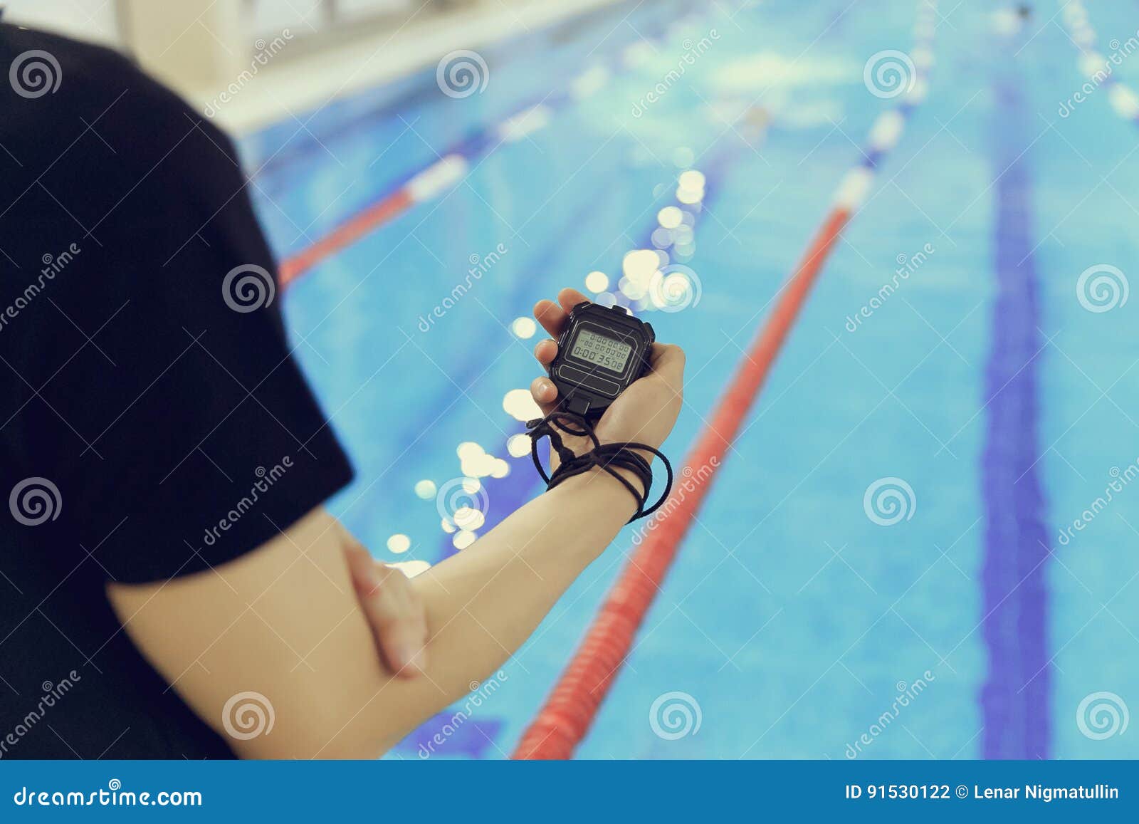 Hand of Coach with a Stopwatch during Competitions in the Swimming Pool ...