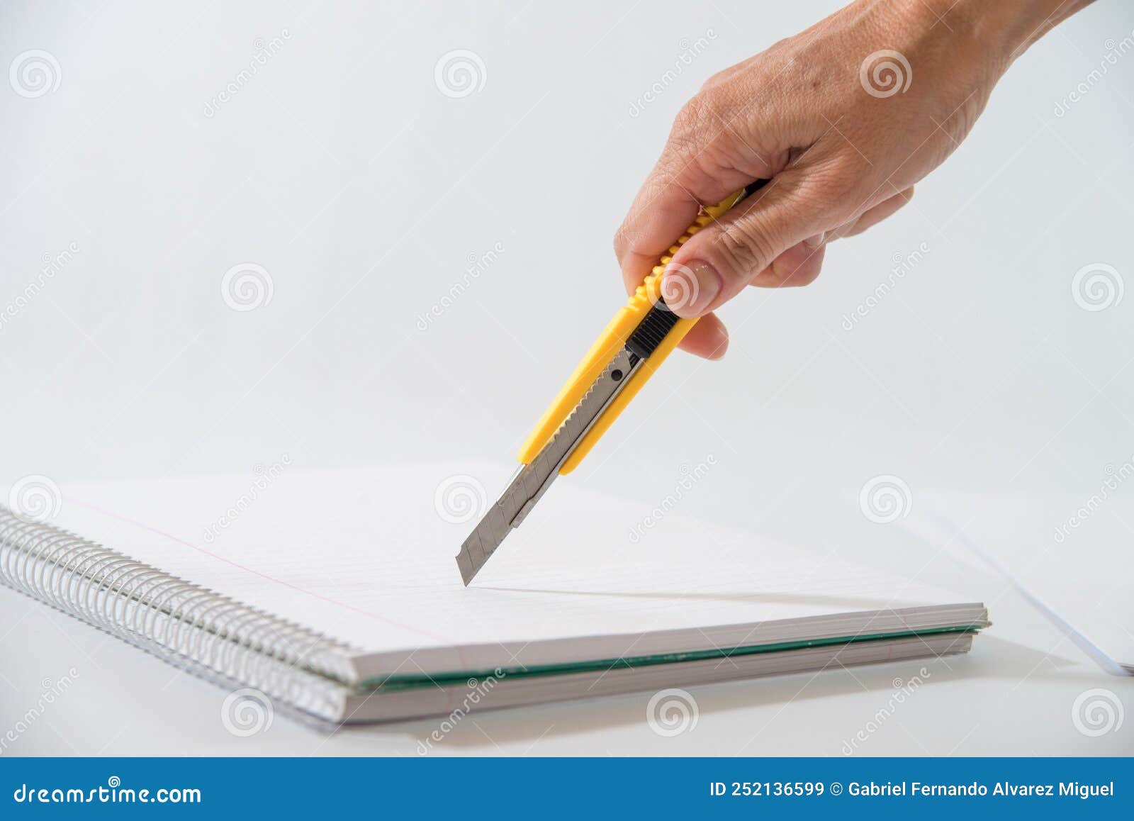 Hand with a Cutter in Hand Cutting the Sheet of a Notebook Stock Image ...