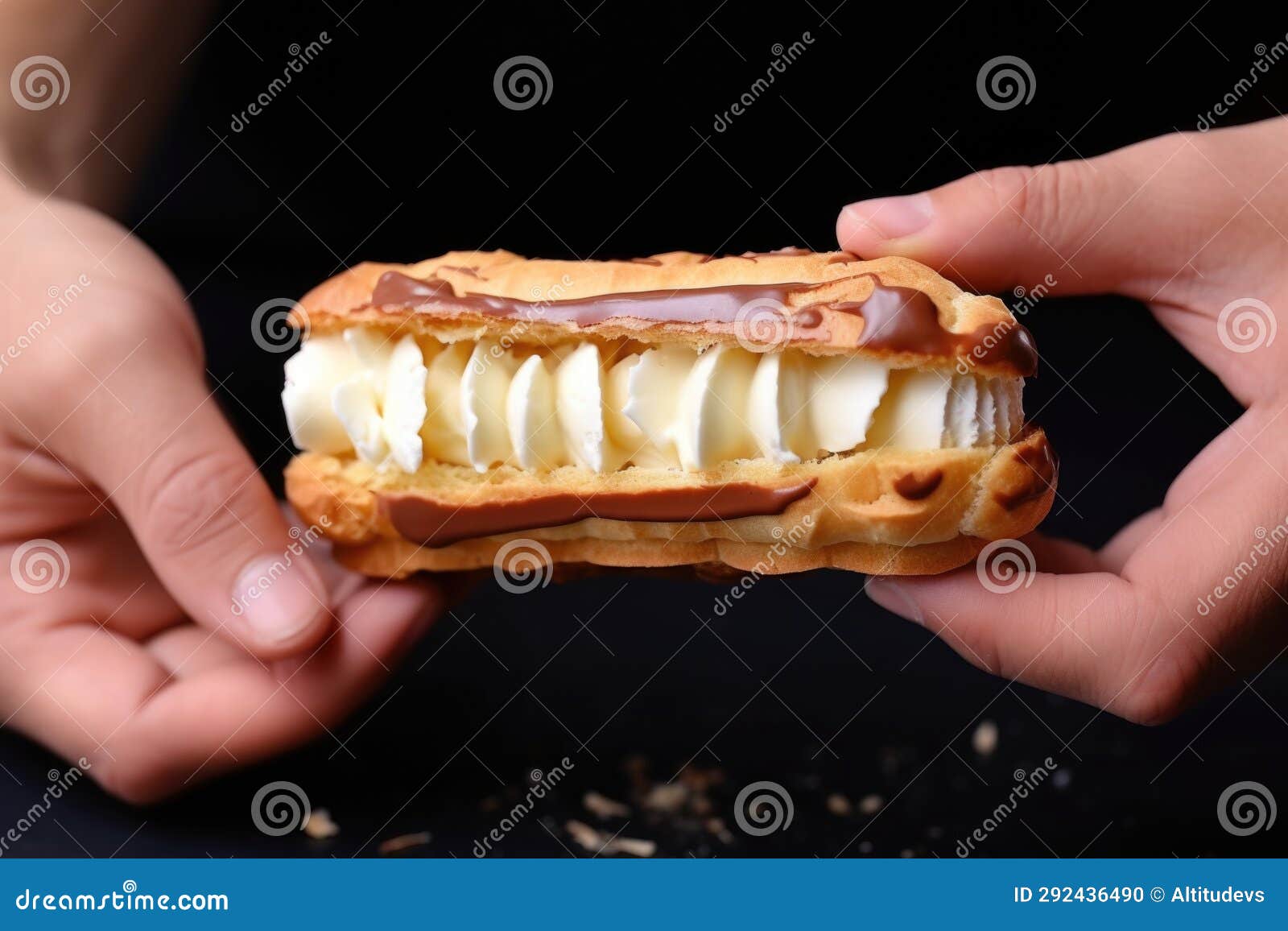 A Hand an Eclair in Half To Reveal Its Creamy Inside Stock Photo ...
