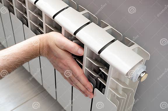 Hand Feeling the Warmth of a Home Radiator, Checking the Heating System ...