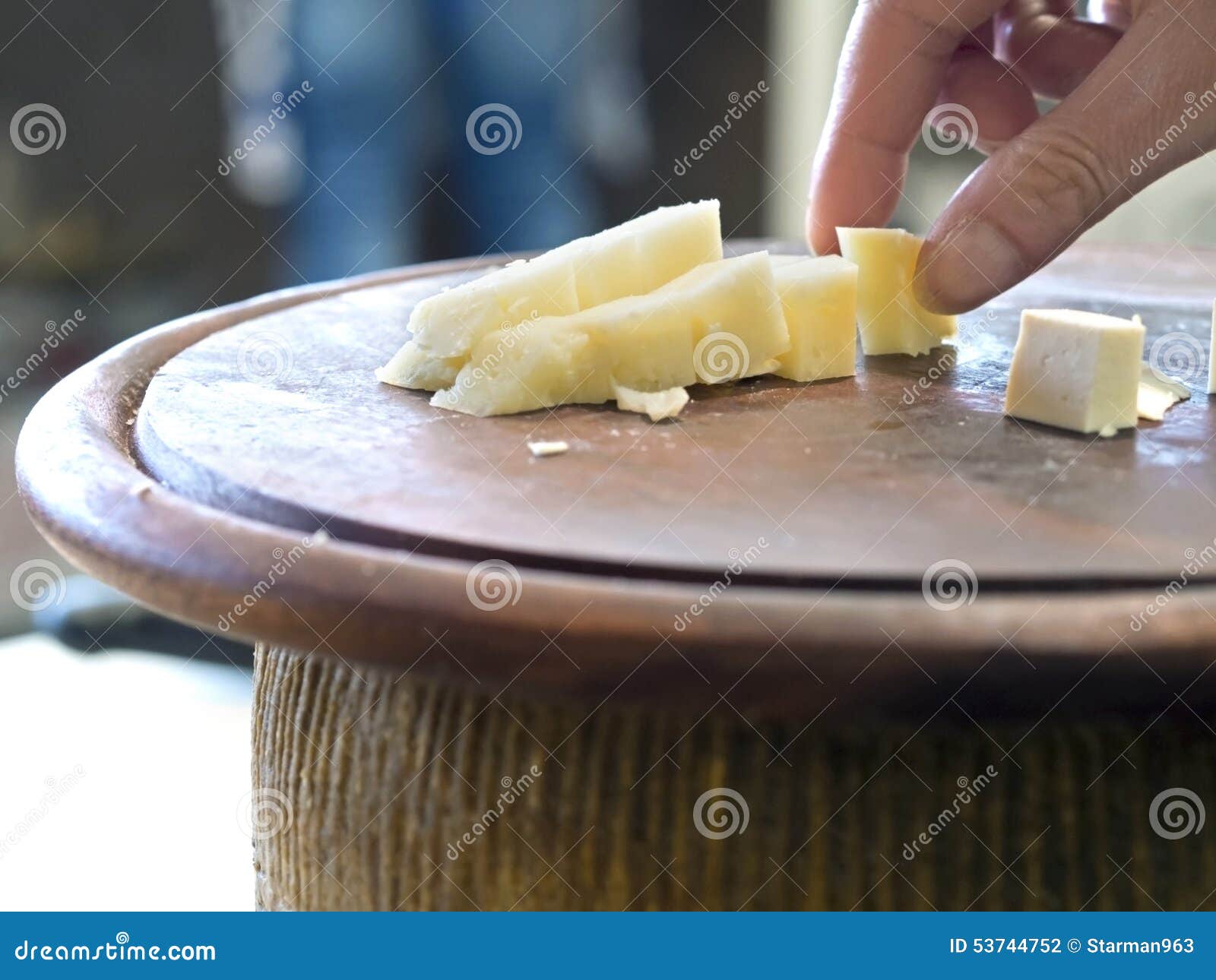 Hand Grasping Cubes of Cheese on a Wooden Cutting Board Ready for ...