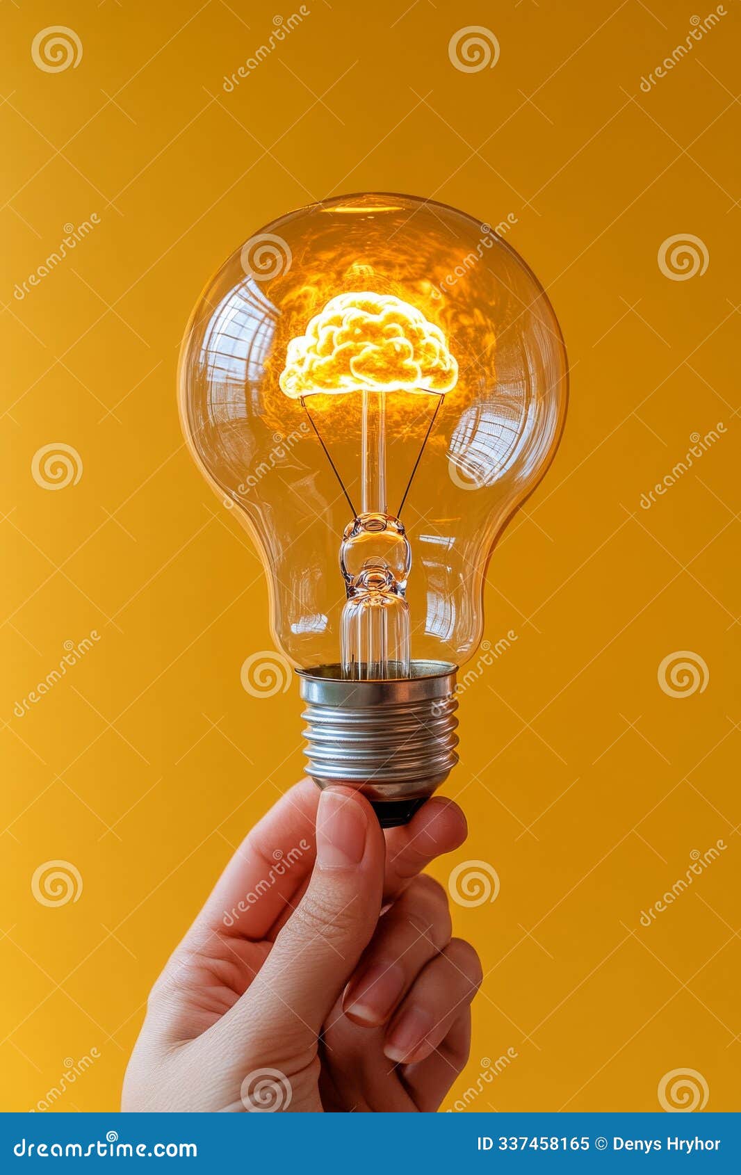 A Hand Grasping a Light Bulb Radiates Bright Light on a Yellow Backdrop ...