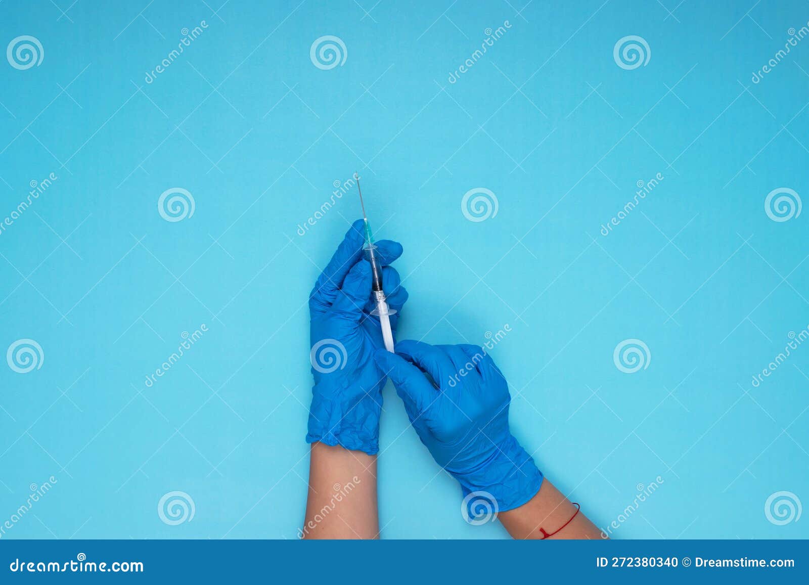 Hand Held Needle with Blue Glove on Light Blue Background Stock Photo ...