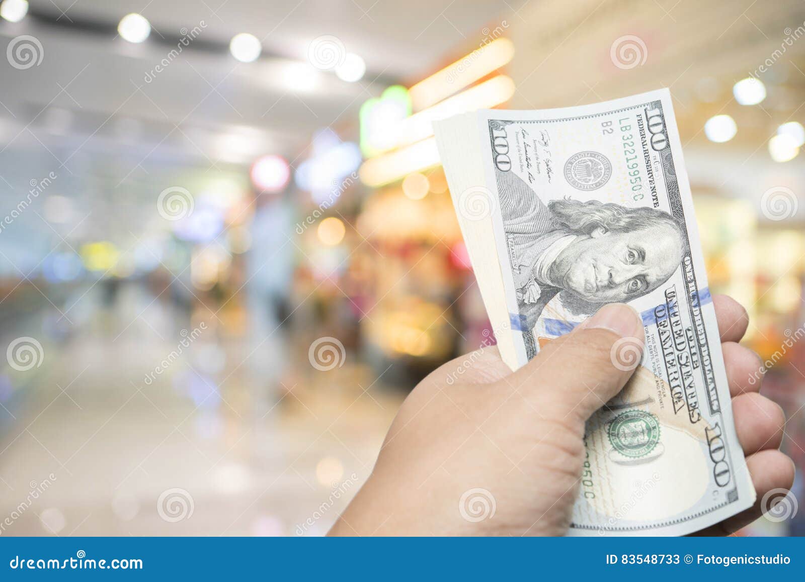 Hand Hold 100 Dollar Bill Over Blur Colorful Background Stock Image ...