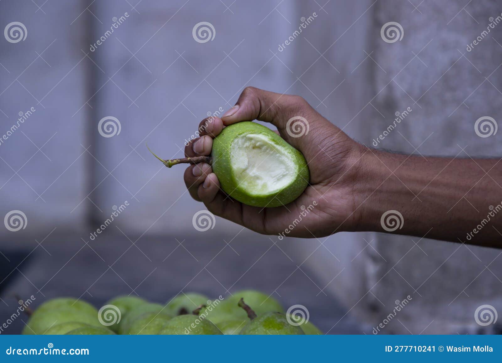 Hand-holding Bite of Raw Green Mango with the Blurry Background Stock ...