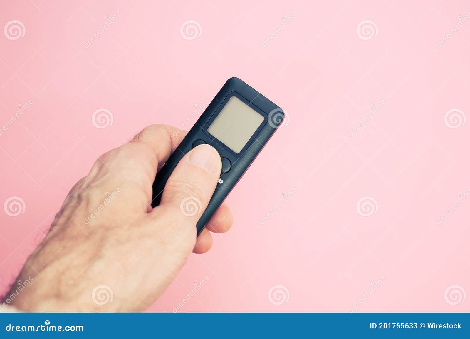 Hand Holding a Black Remote Controller on Pastel Pink Background for a ...