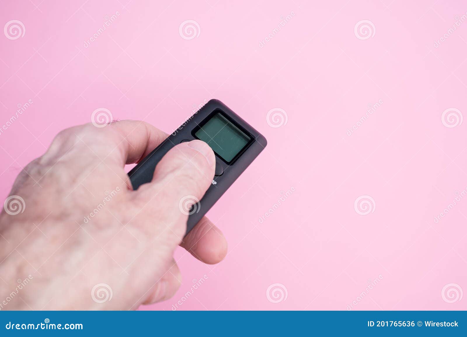 Hand Holding a Black Remote Controller on Pastel Pink Background for a ...