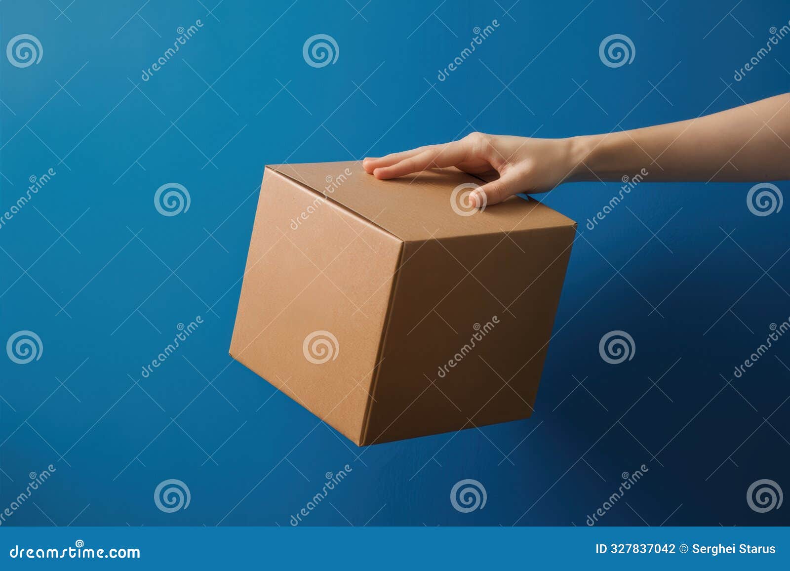 A Hand Holding a Box Against Blue Background with Some Light Coming ...