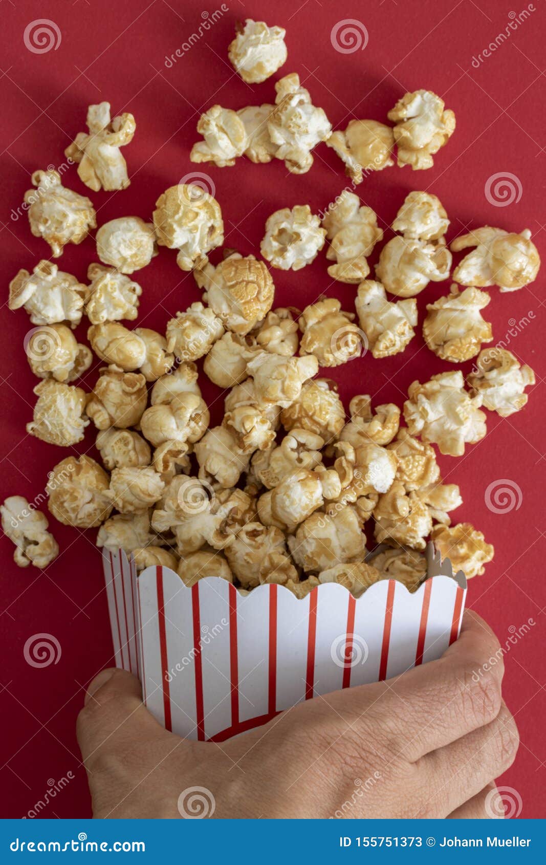 Hand Holding a Box of Popcorn and Popcorn Falling Out of it Stock Image ...