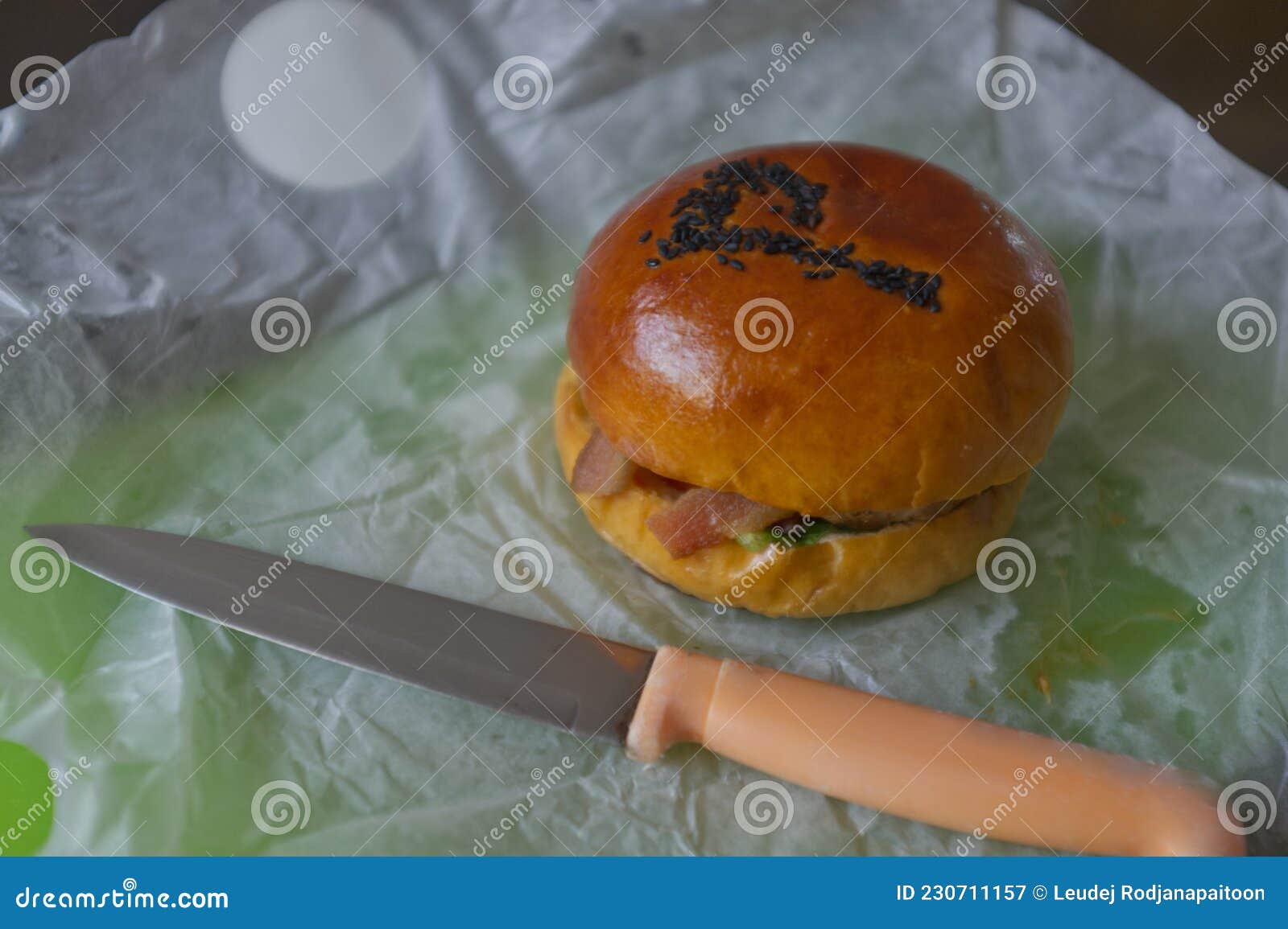 Hand Holding a Burger Bun and Cutting in Half Stock Image - Image of ...
