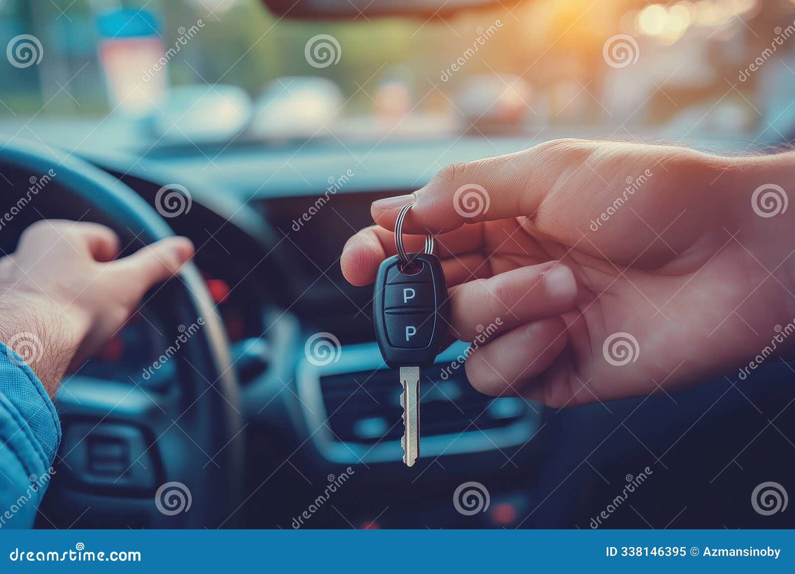 A Hand Holding a Car Key while Another Hand is on the Steering Wheel ...