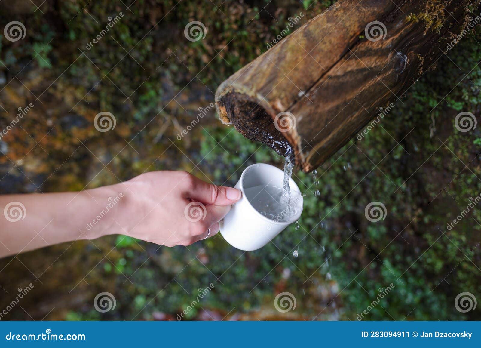 Hand Holding a Ceramic Cup with Water Flowing into it from a Spring ...