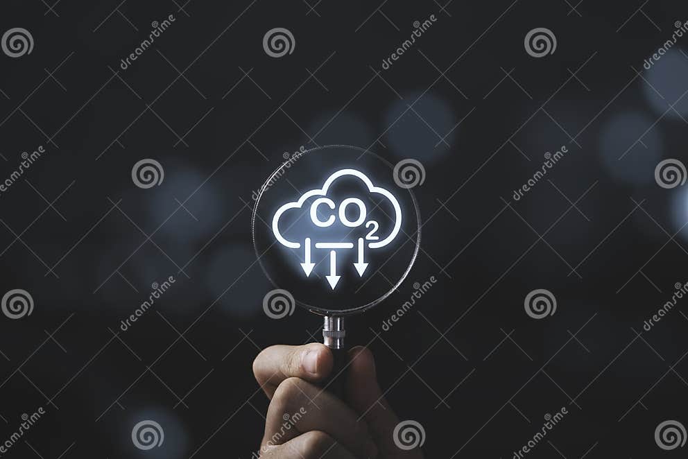 Hand Holding CO2 Reducing Icon Inside Magnifier Glass for Focusing Decrease CO2 or Carbon ...