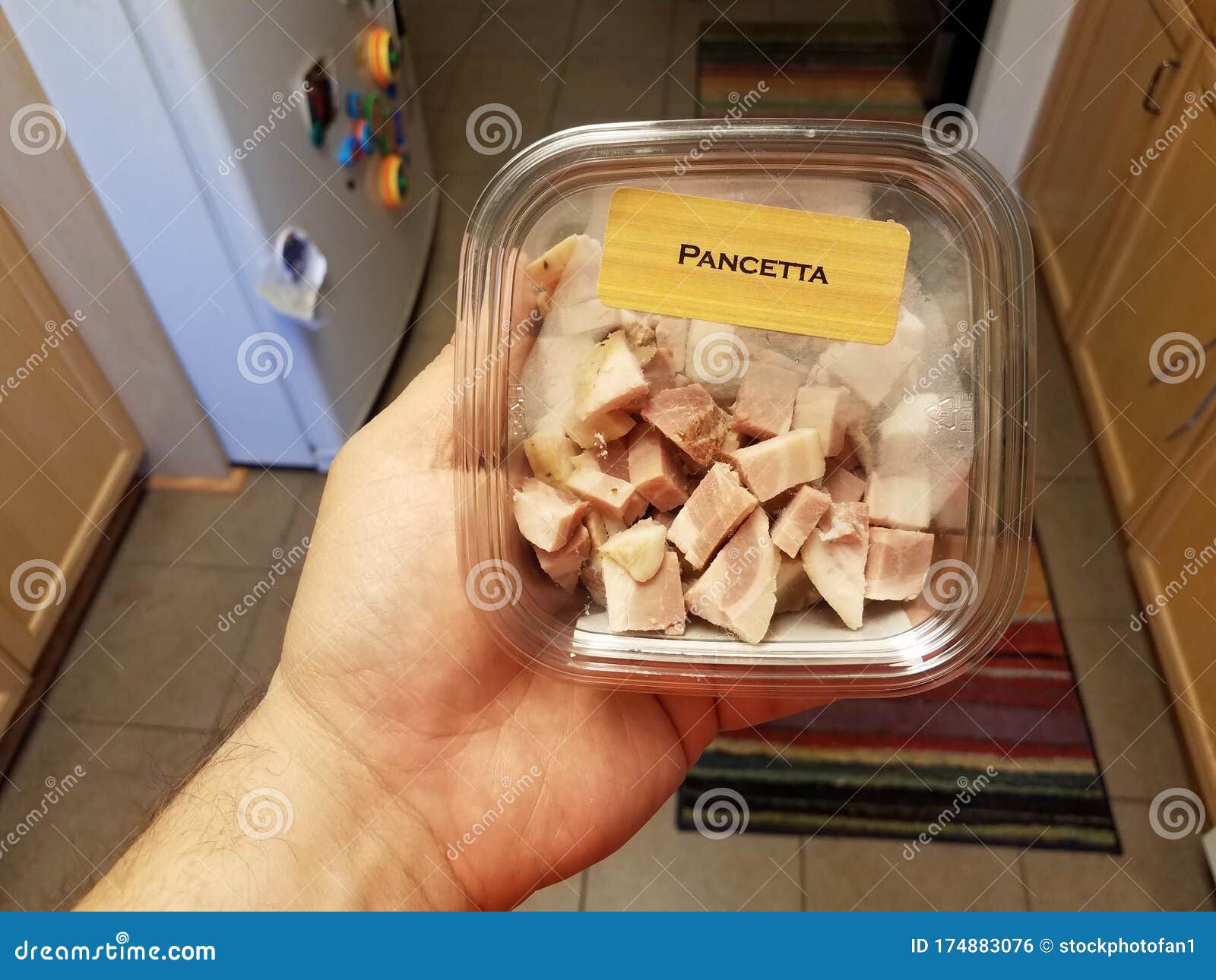 Hand Holding Container of Pancetta Meat in Kitchen Stock Photo - Image ...