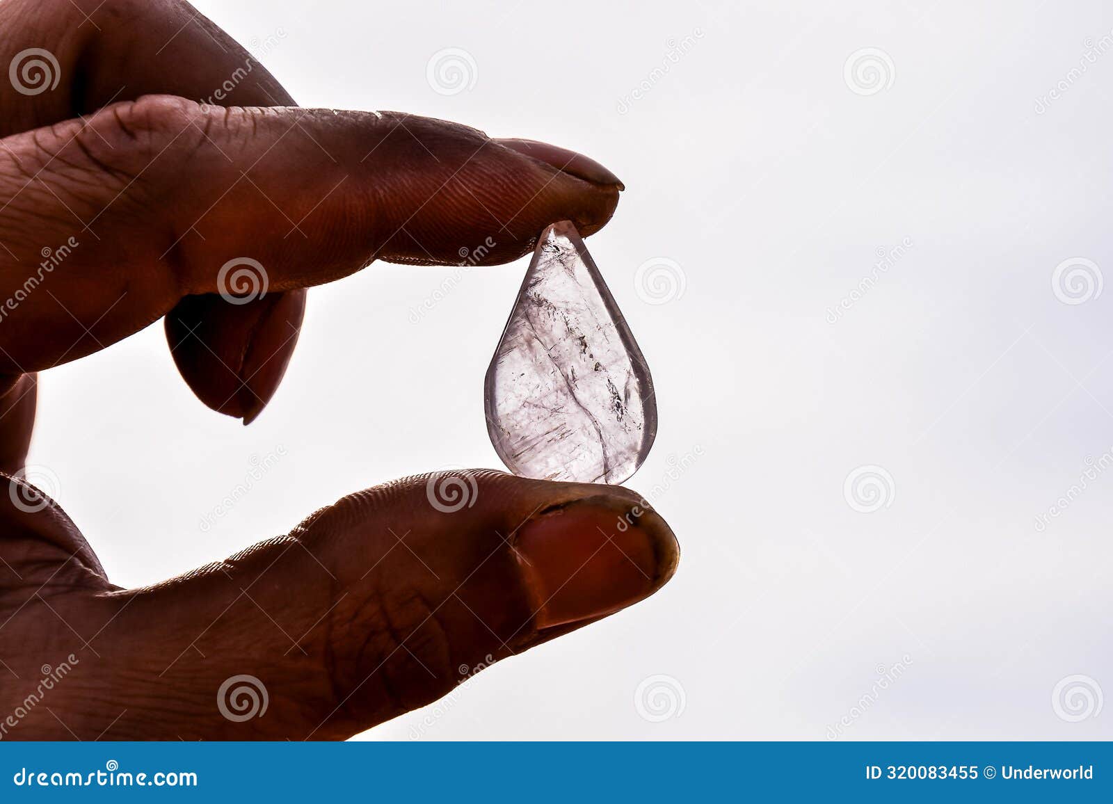 A Hand Holding a Crystal Shaped Like a Drop Stock Image - Image of ...