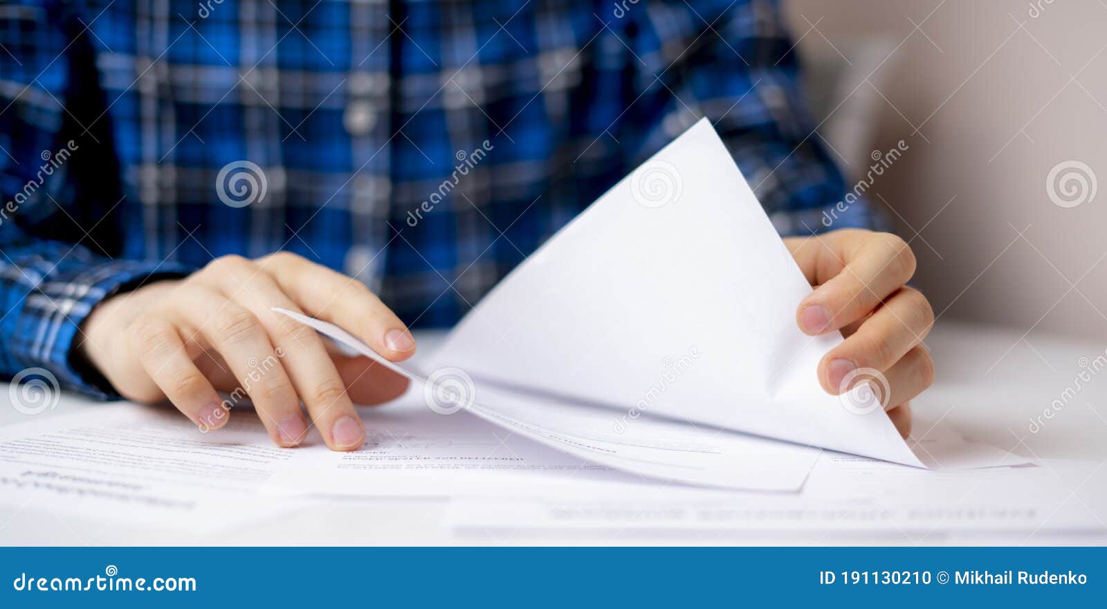 A Hand Holding a Document Sheet, Doing Some Paper Work in the Office ...