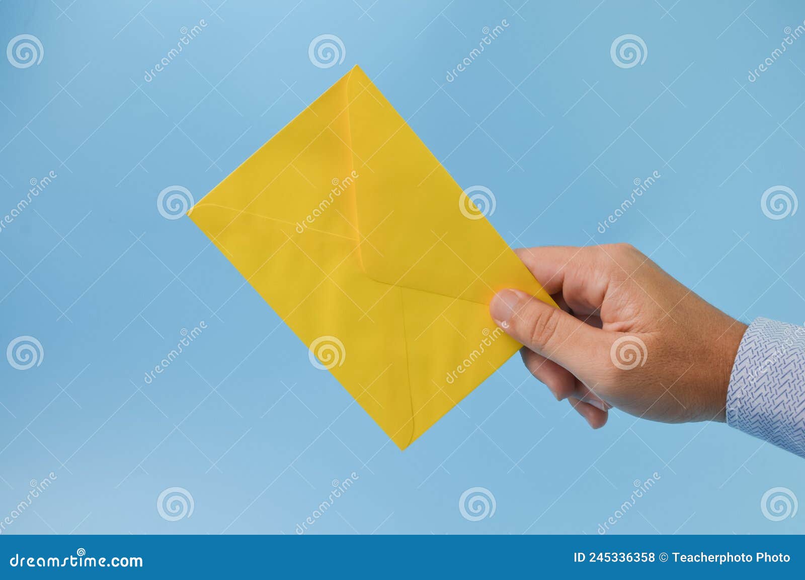 Hand Holding Envelope on a Blue Background Stock Photo - Image of ...