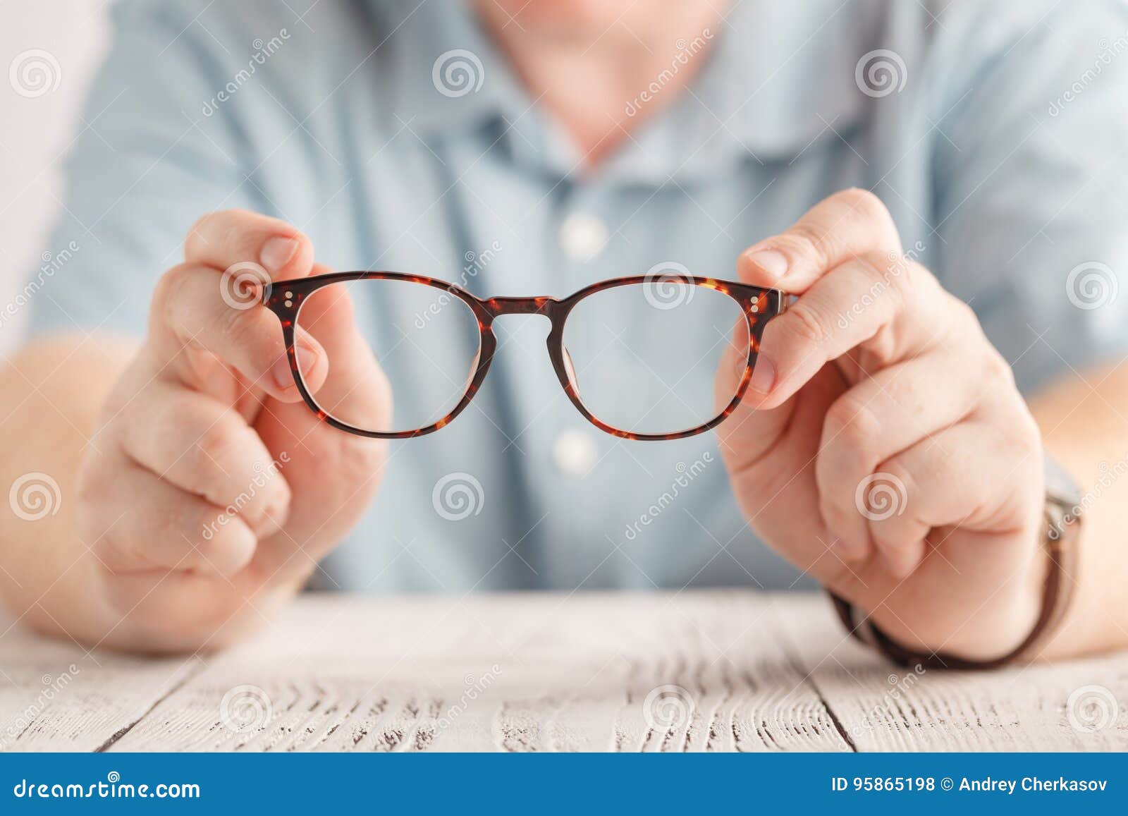 Hand holding glasses stock photo. Image of eyesight, table - 95865198