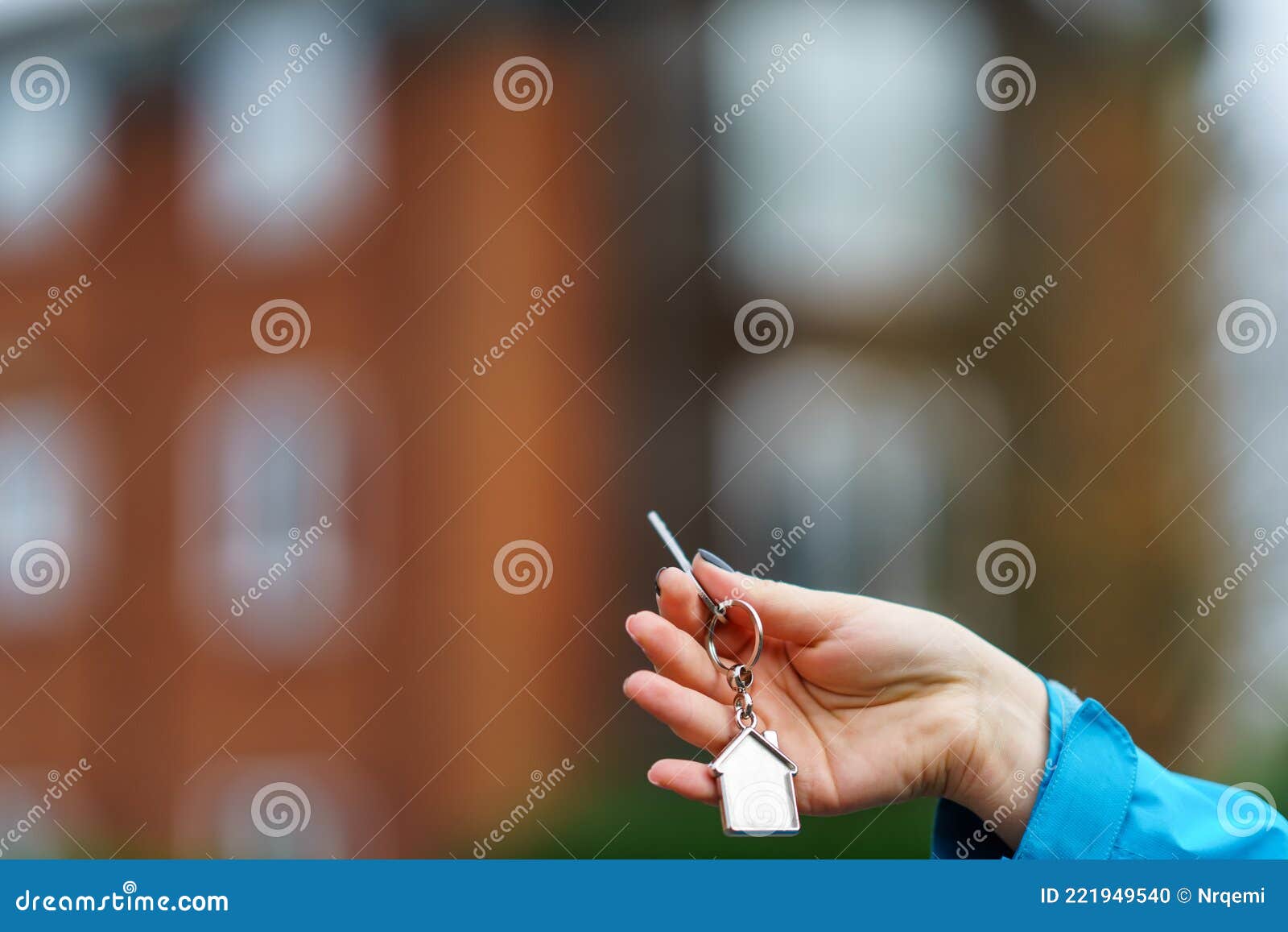 Hand Holding House Key in Front of a Large House. Stock Photo - Image ...