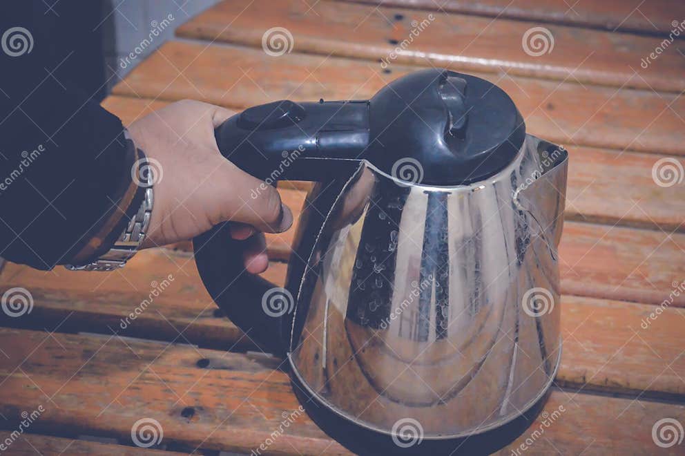Hand holding kettle stock photo. Image of utensil, hand - 90033200