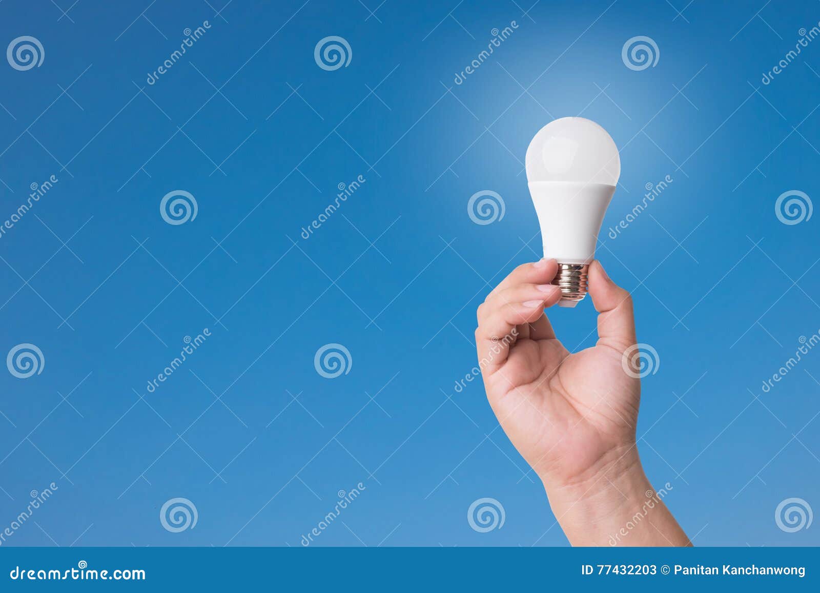 Hand Holding LED Bulb with Lighting on Blue Sky Background. Stock ...