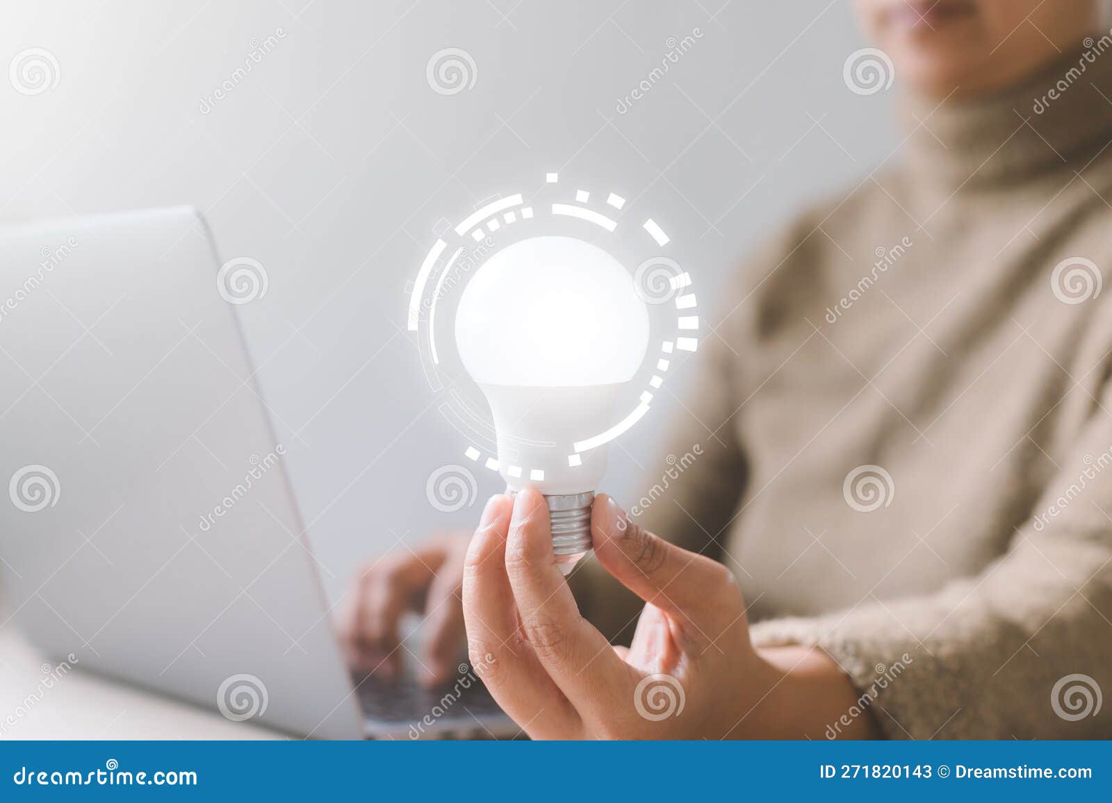 Hand Holding a Light Bulb and Using a Notebook Computer. Success ...