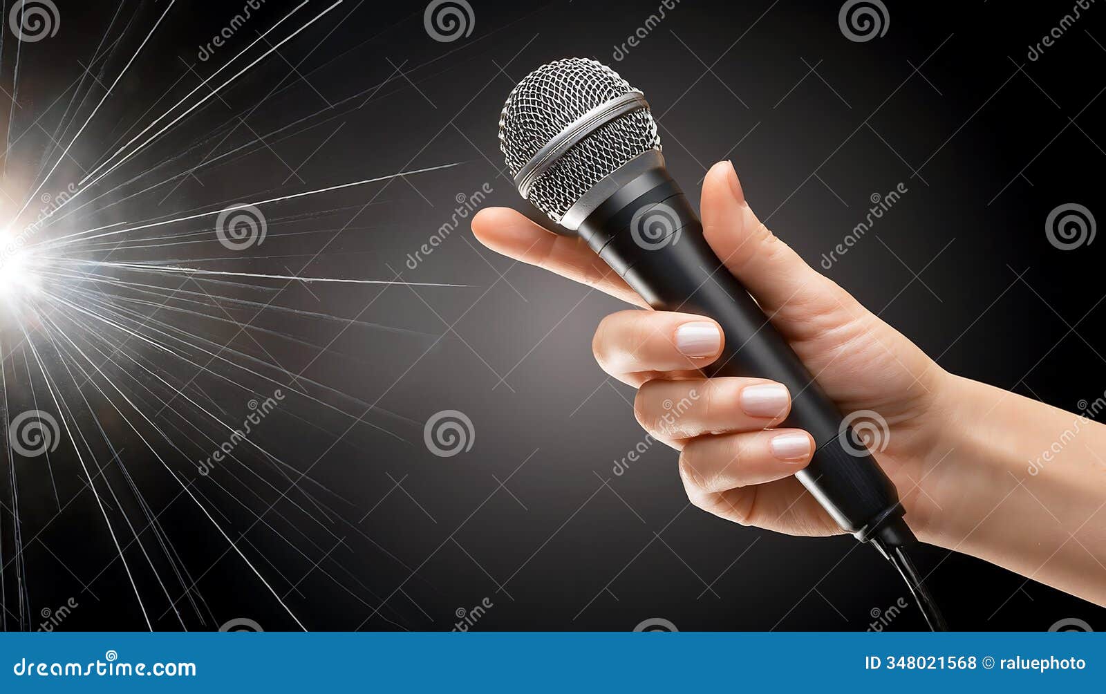 A Hand is Holding a Microphone with a Bright Light Shining in the ...