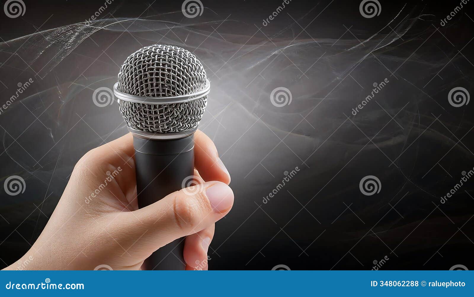 A Hand is Holding a Microphone with a Bright Light Shining in the ...