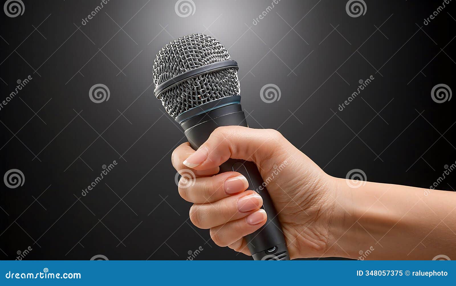 A Hand is Holding a Microphone with a Bright Light Shining in the ...