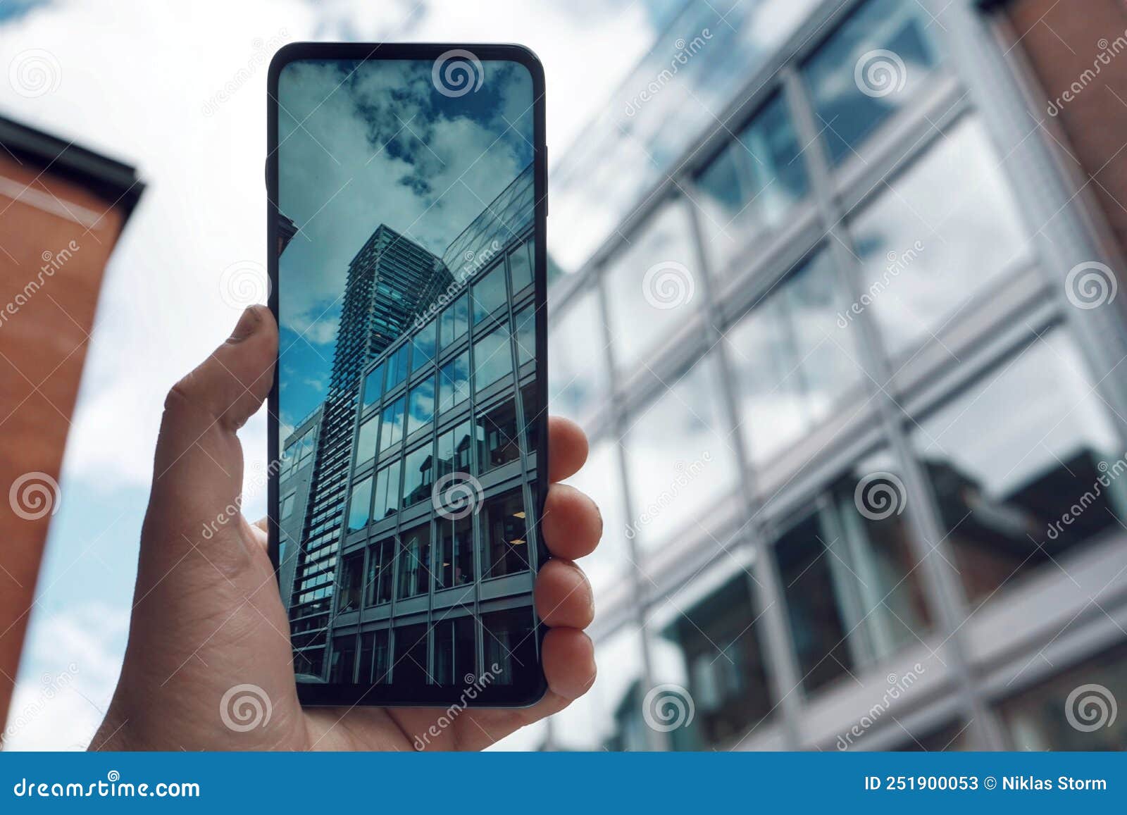 Hand Holding Mobile Phone with Image on Screen Against Building Stock ...