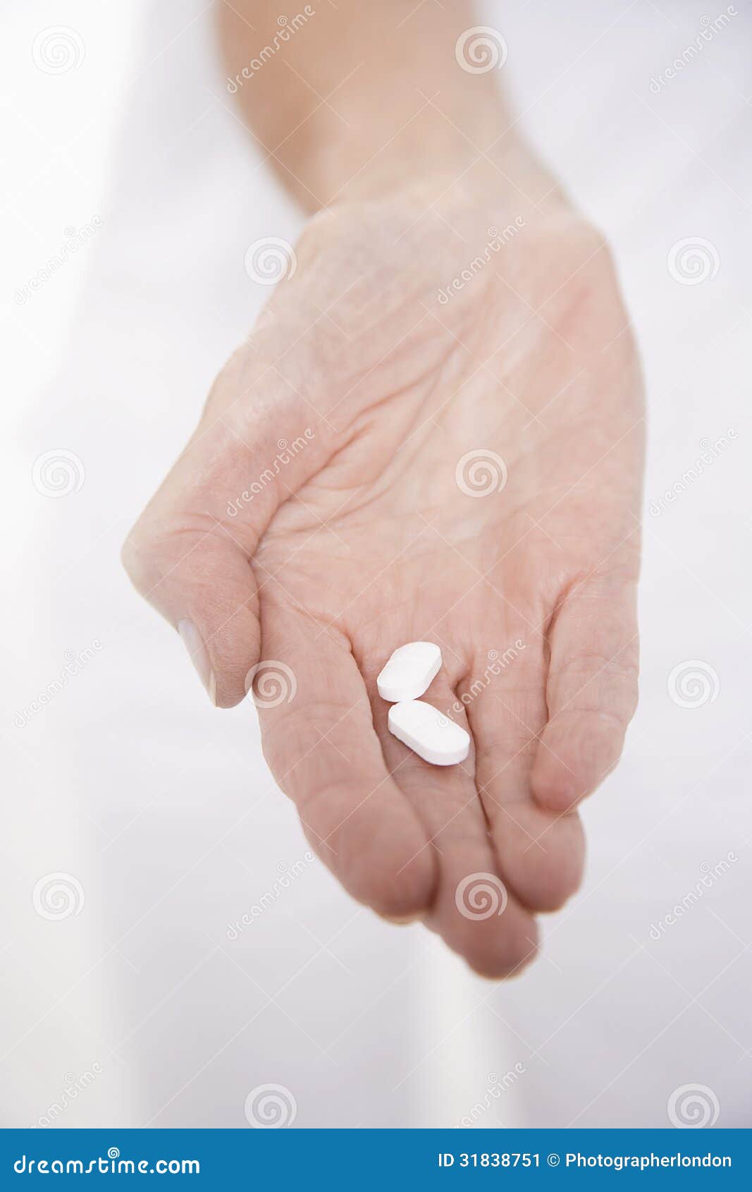 Hand Holding Out Two Pills stock image. Image of dose - 31838751