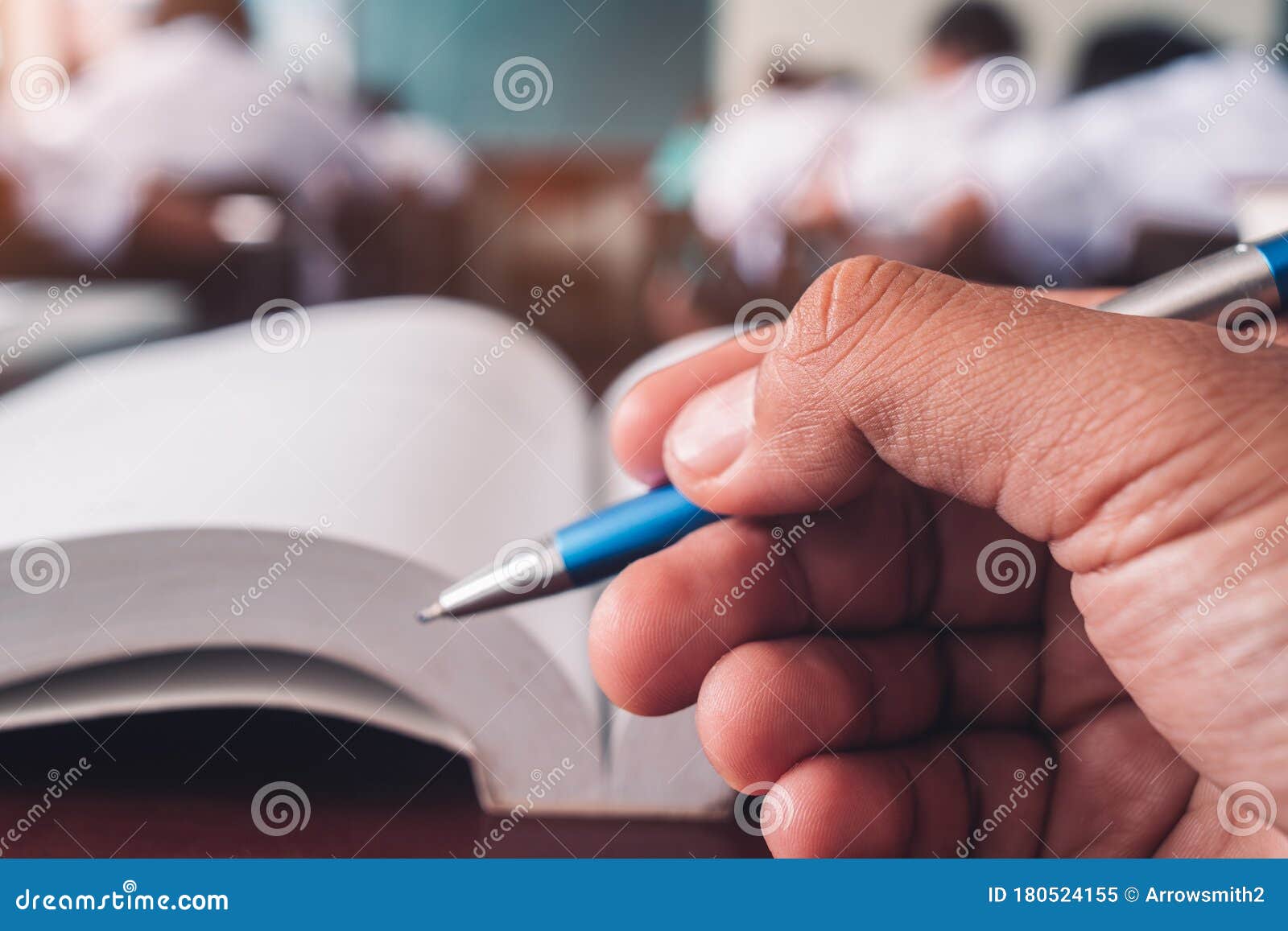 The Hand Holding a Pen and Reading Book with Uniform School Students ...