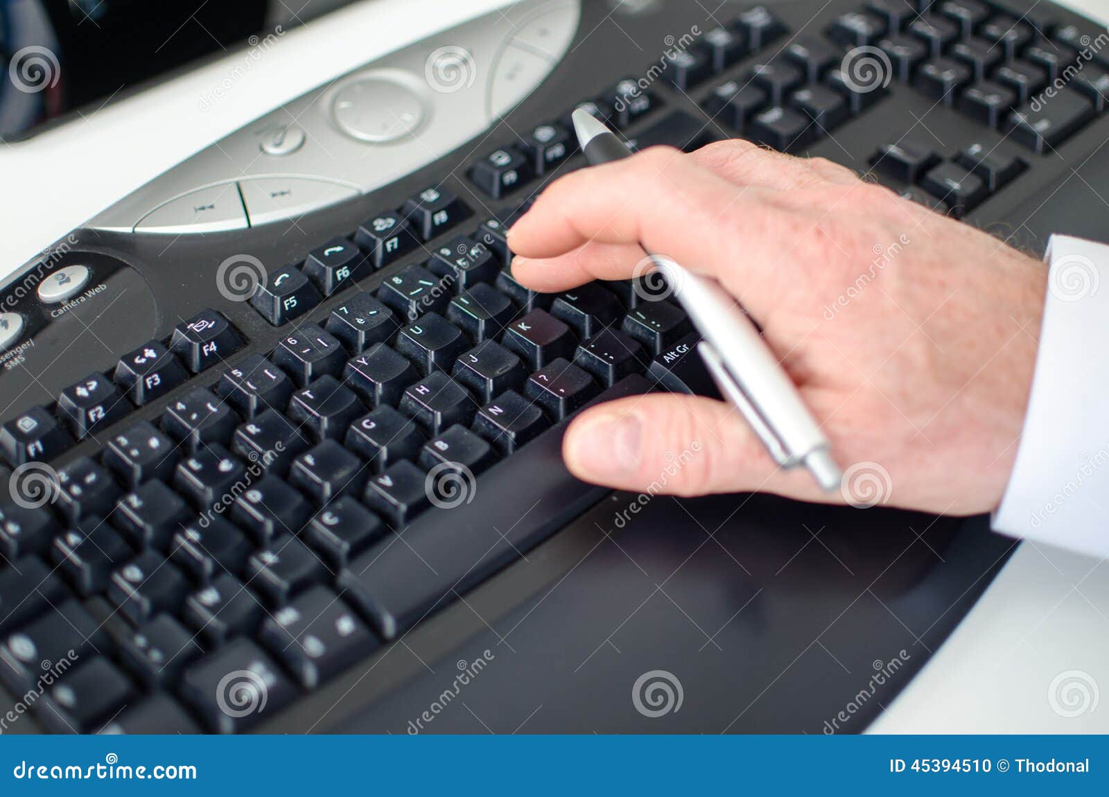 Hand Holding a Pen and Typing on a Keyboard Stock Photo - Image of ...