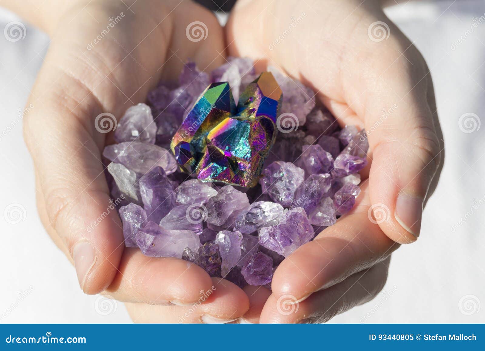 A Hand Holding a Pile of Amethyst and a Rainbow Titanium Aura Piece ...
