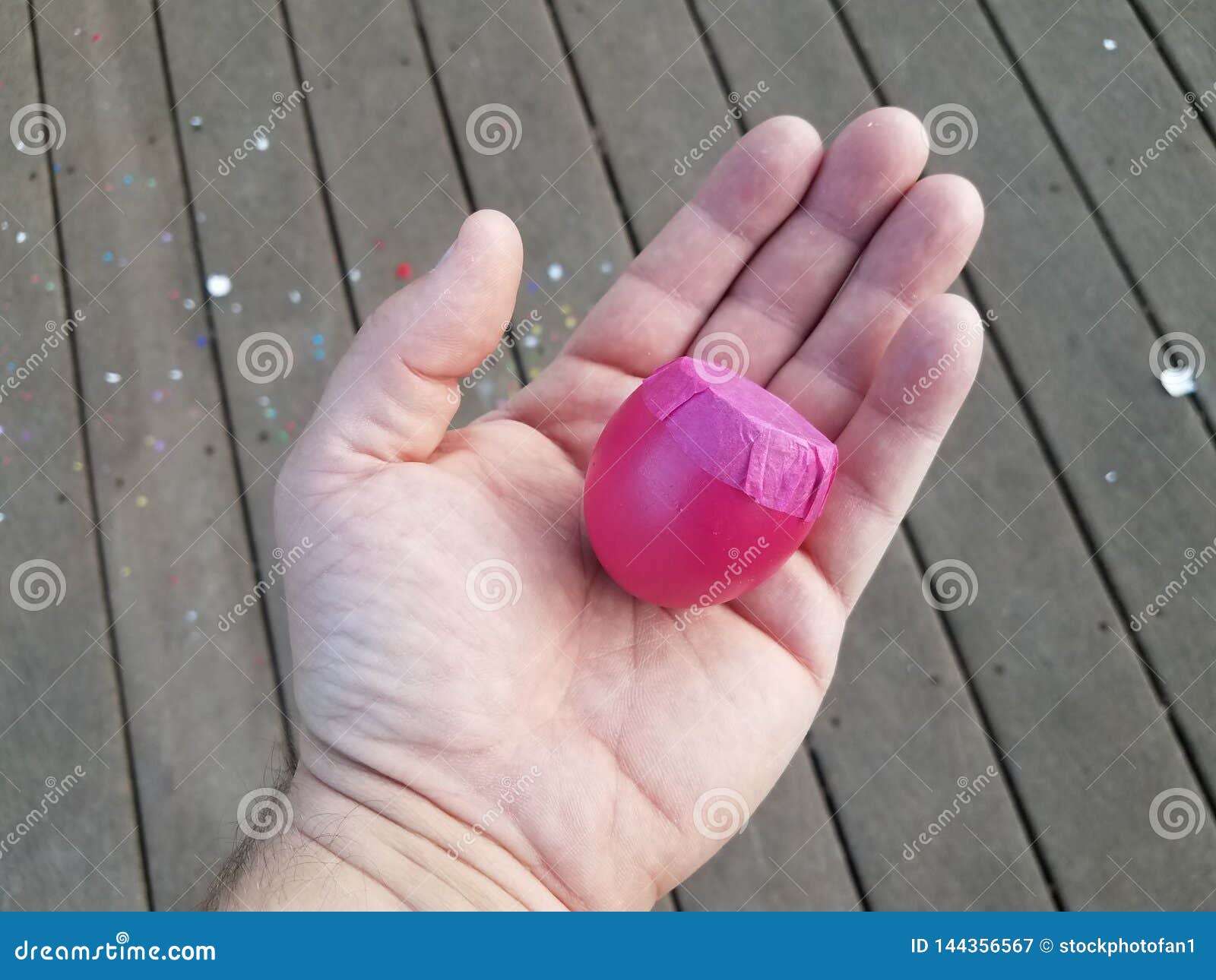 Hand Holding Pink Egg Shell with Confetti on Wood Deck Stock Image ...