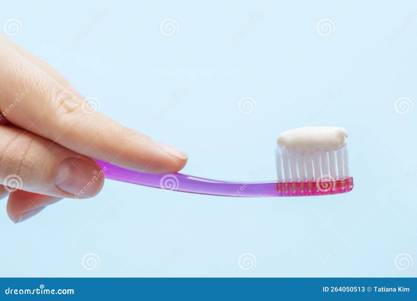 Hand Holding Pink Toothbrush with Toothpaste on a Blue Background Close ...