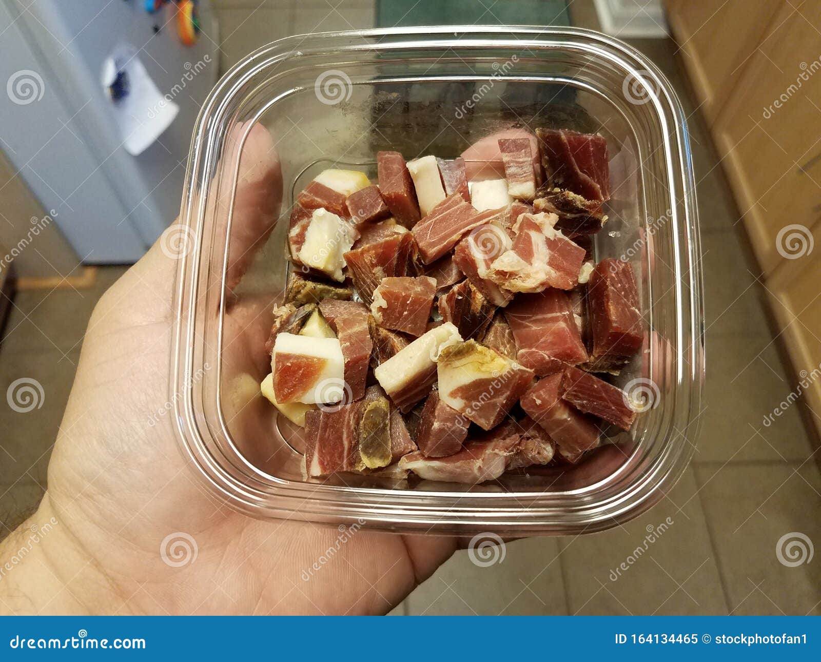 Hand Holding Plastic Container of Ham with Fat in Kitchen Stock Image ...
