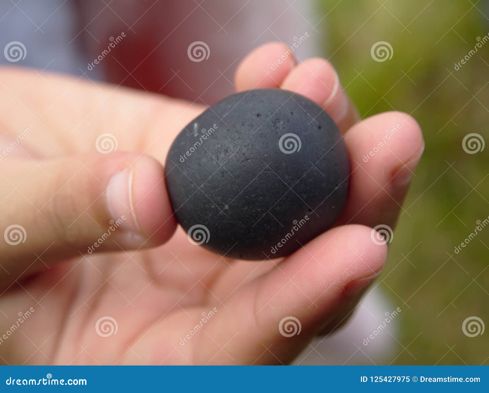 Hand holding a round rock stock image. Image of stones - 125427975 Hand holding a round rock stock image. Image of stones - 125427975