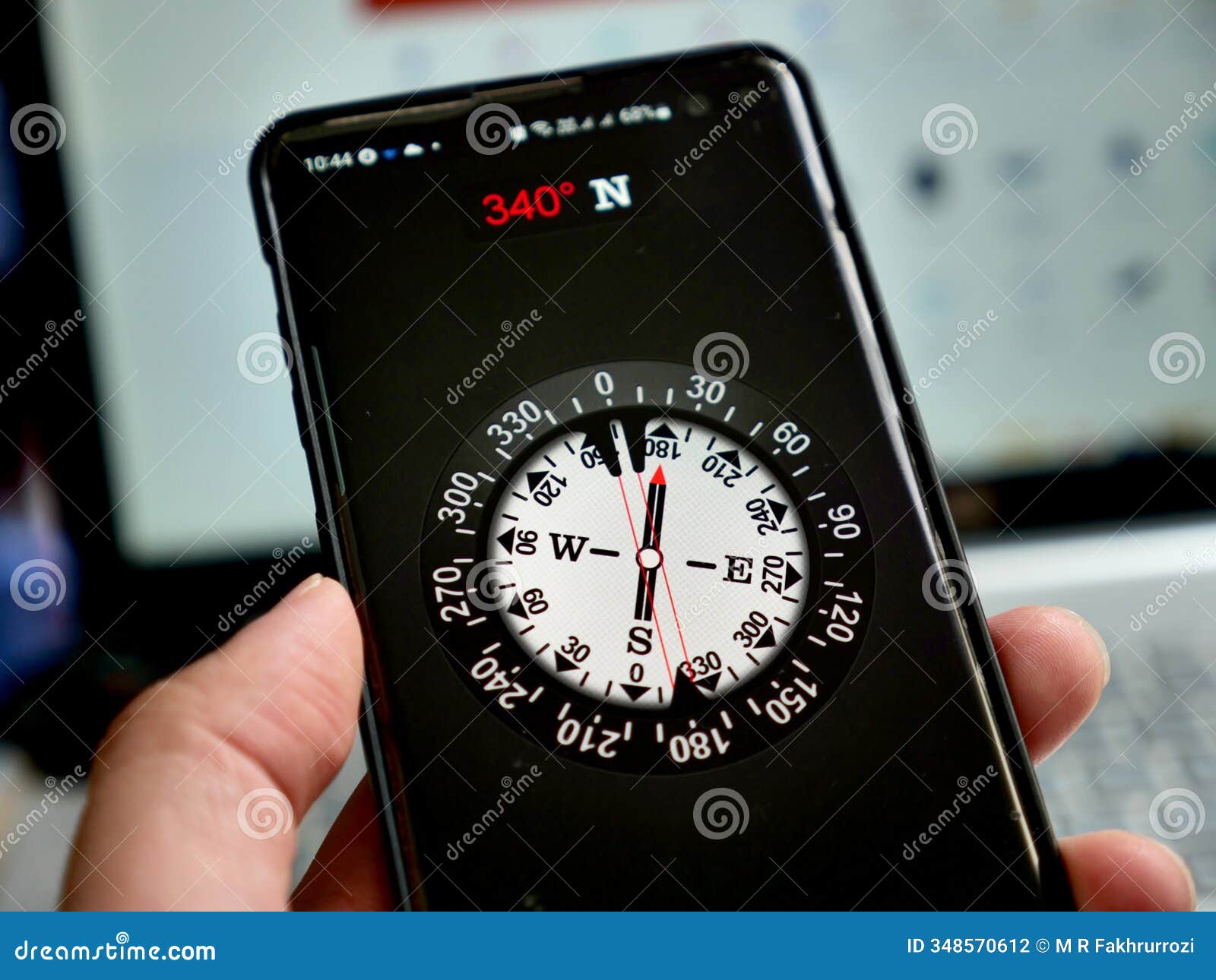 Hand Holding Smart Phone with Digital Compass App Shown on Its Screen ...