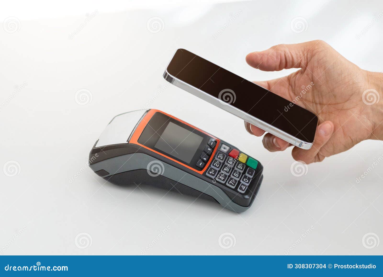Hand Holding a Smartphone Above a Card Payment Terminal, Indicating a ...