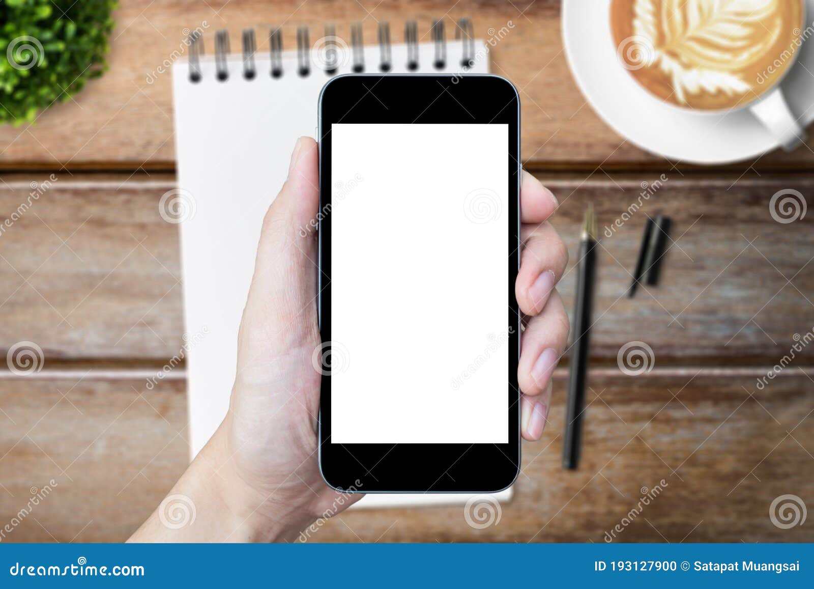 Hand is Holding Smartphone with Blank Screen Over the Wood Office Table ...
