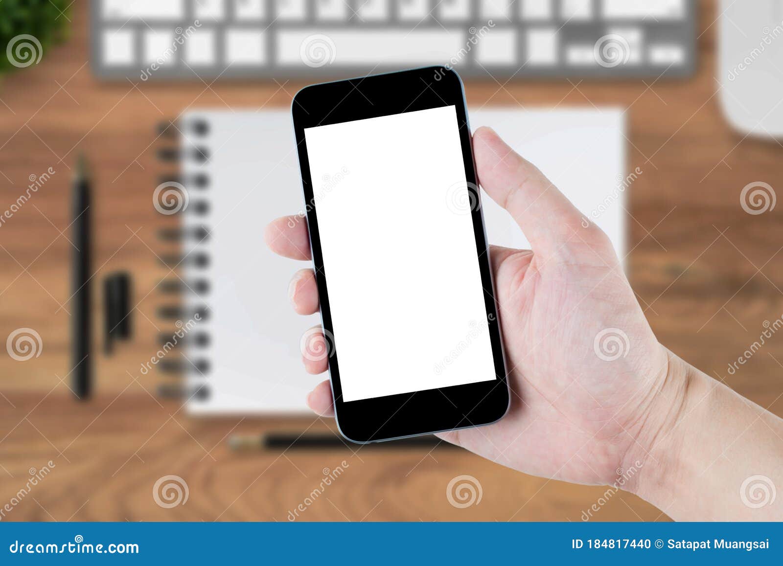 Hand Holding Smartphone with White Blank Screen Over Wood Desk Table ...