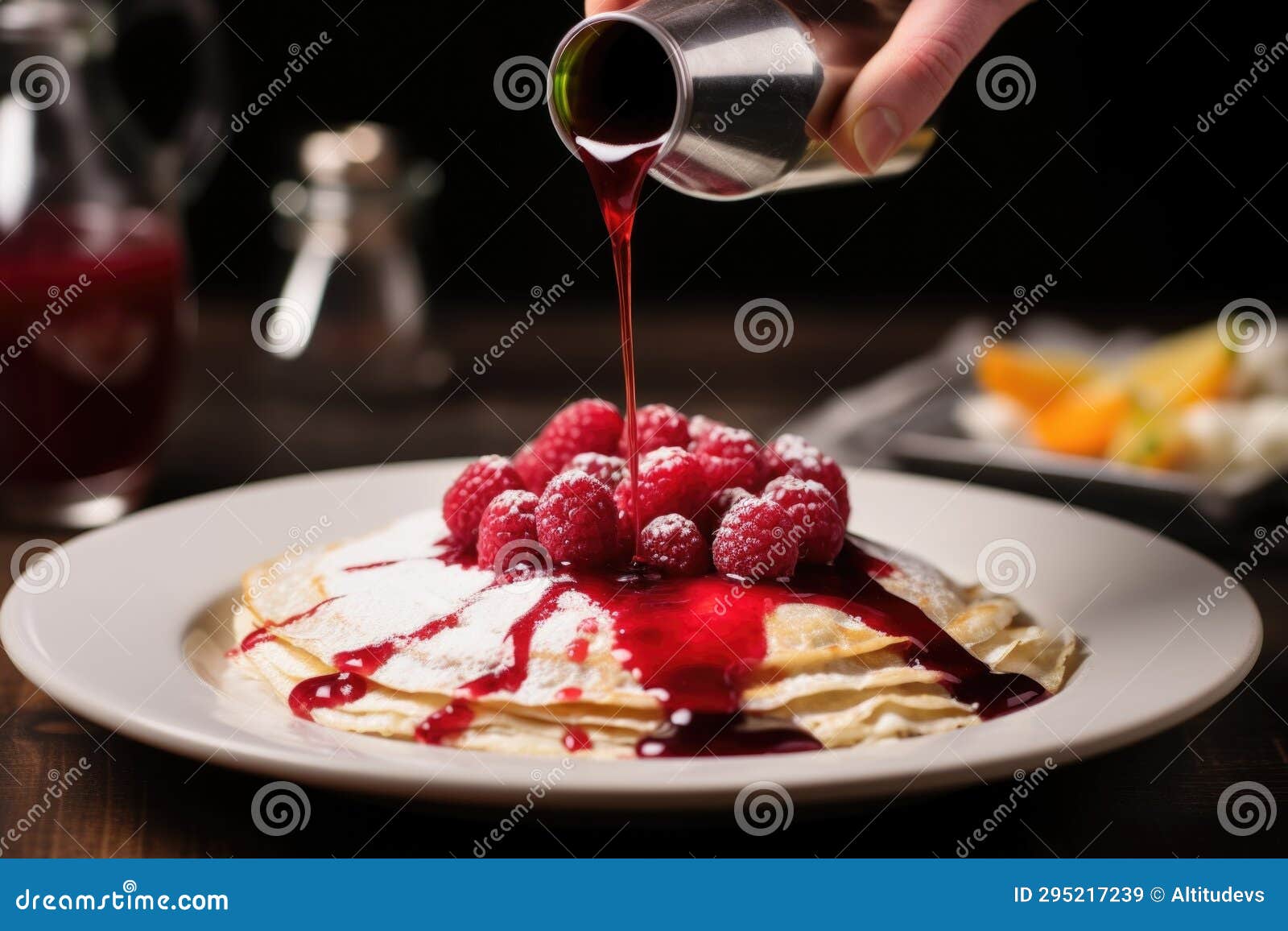 Hand Holding a Spoon Pouring Raspberry Sauce Onto a Crepe Stock Image ...