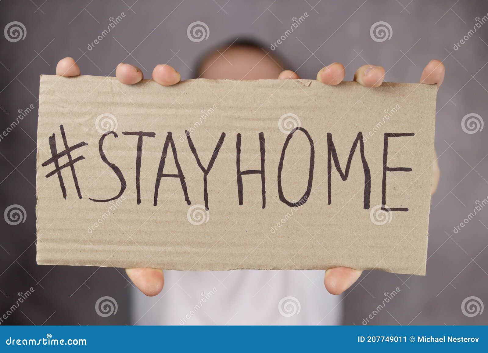 Hand Holding a Stay Home Poster on a Gray Background Stock Image ...