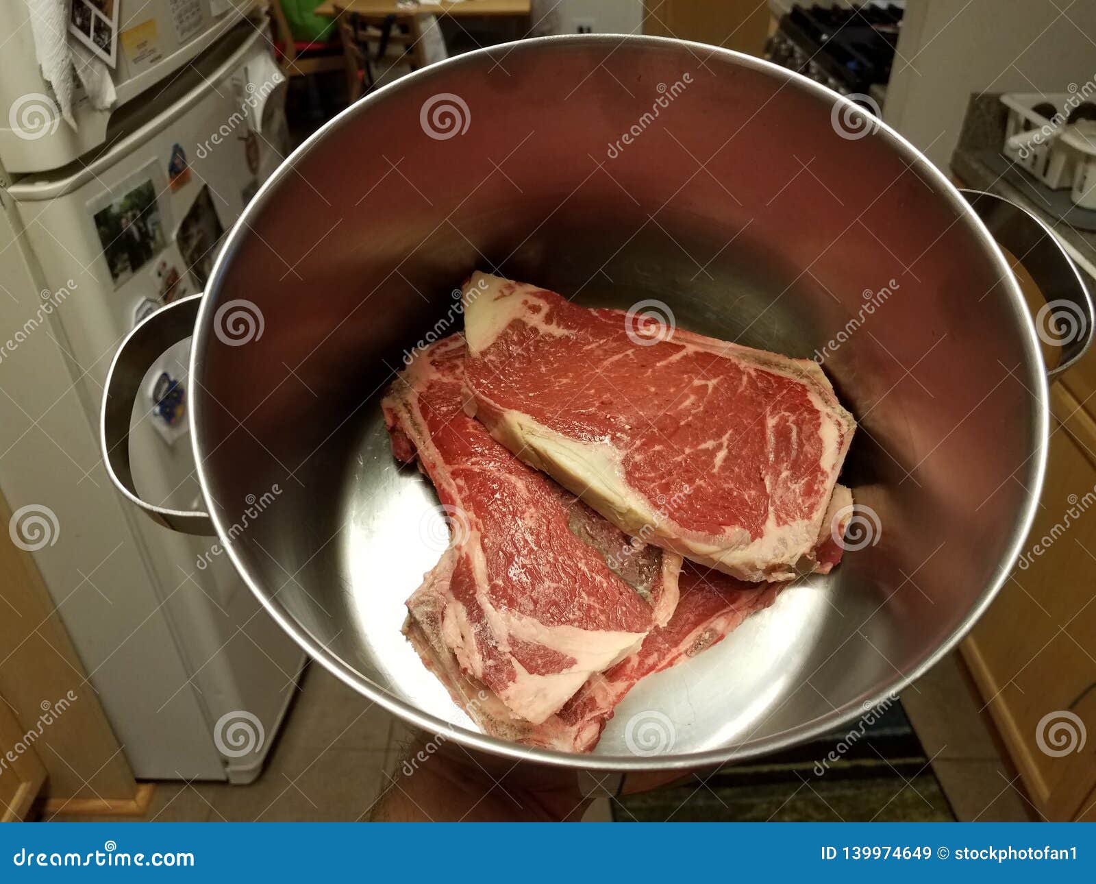 Hand Holding Steak in Metal Pot in Kitchen Stock Image - Image of meat ...