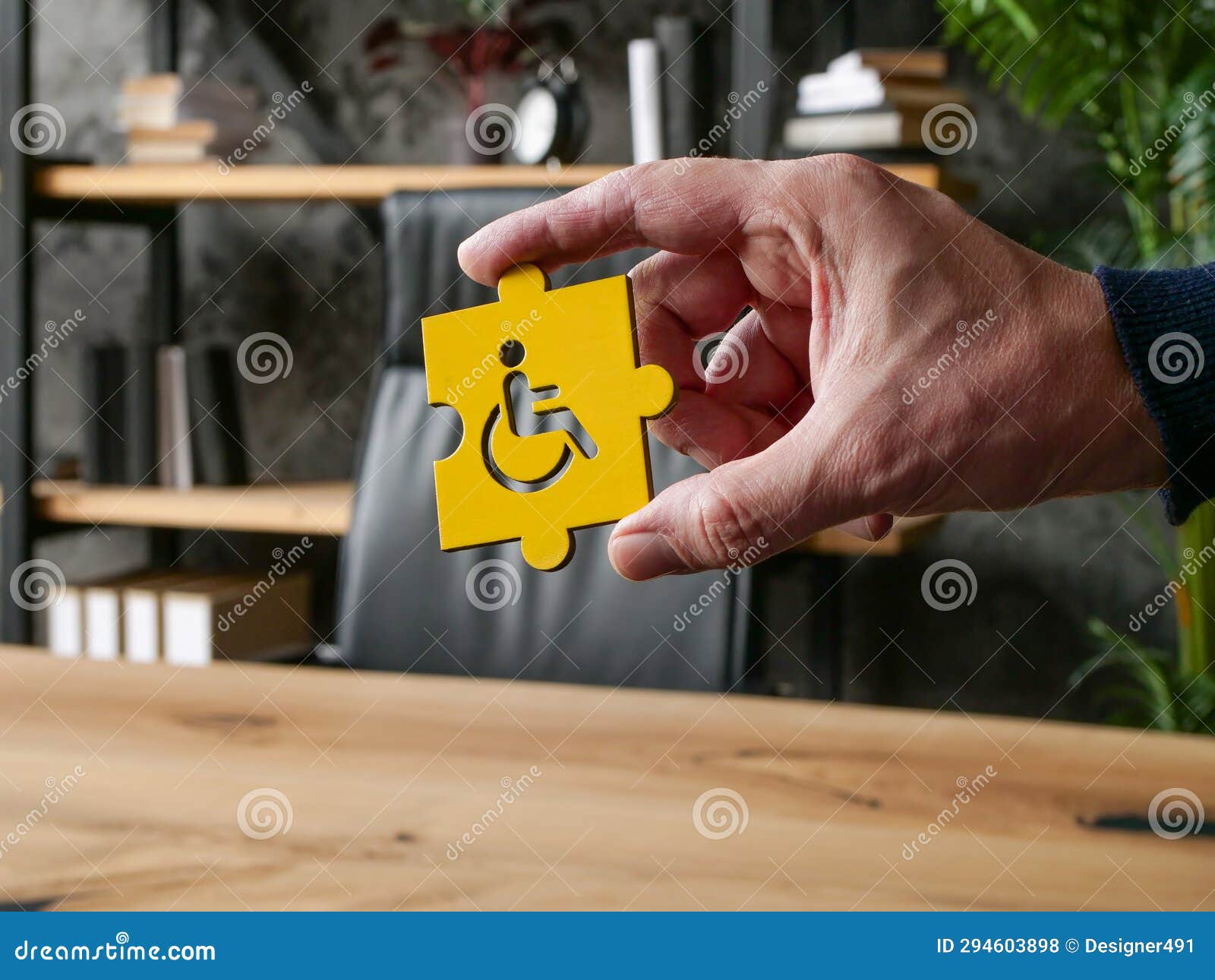 A Hand Holds Puzzle Disabled Person Symbol in the Workplace As a Symbol ...