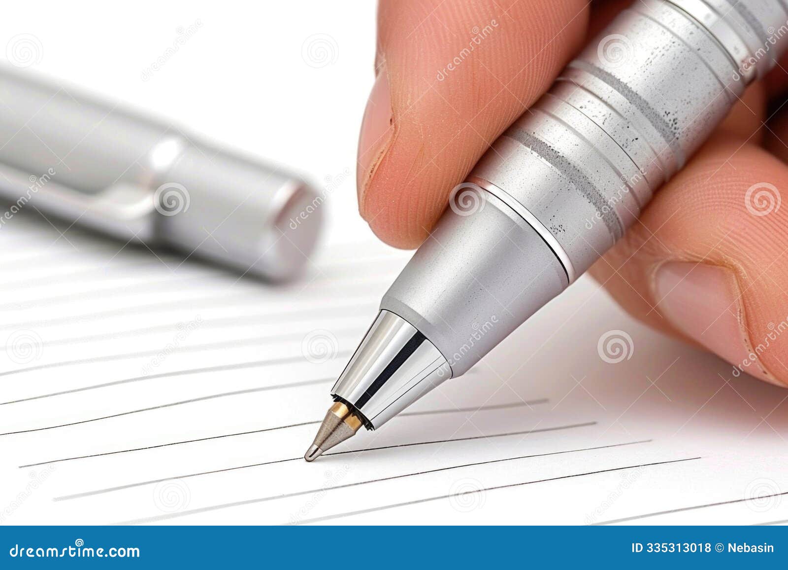A Hand Holds a Silver Pen, Poised Above a Sheet of Lined Paper, Ready ...