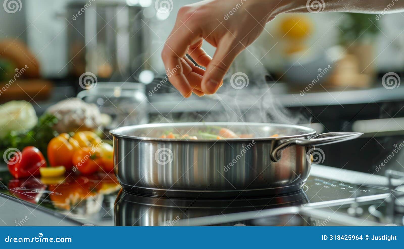 A Hand Hovering Over an Induction Cooktops Control Panel Adjusting the ...