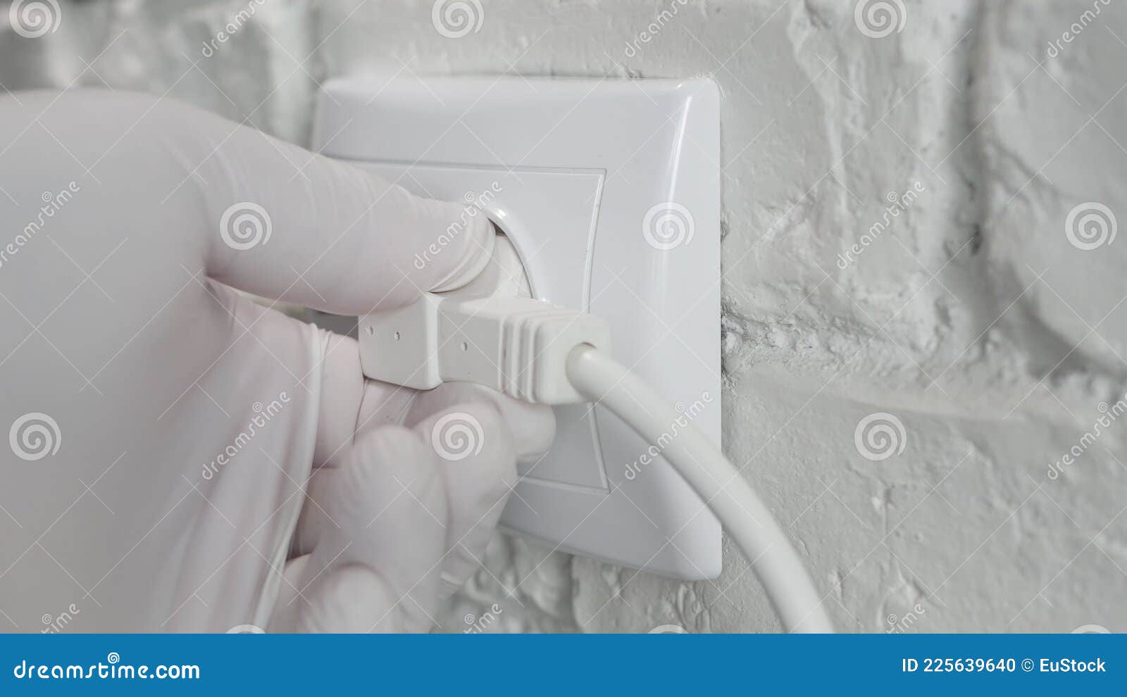 A Hand Inserting an Electrical Power Cord into a Socket on the Wall in ...